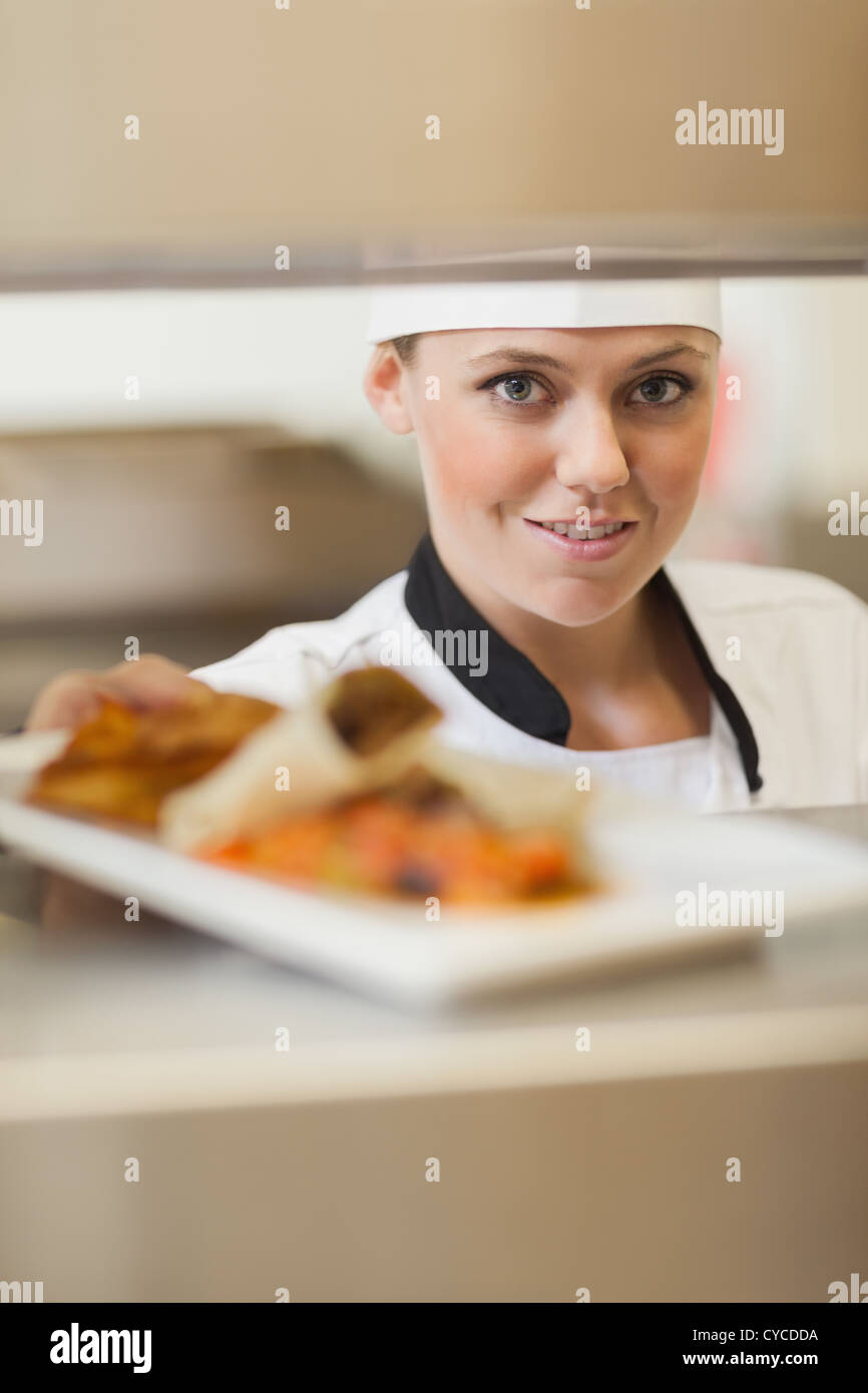 Chef handing plate through order station Stock Photo - Alamy