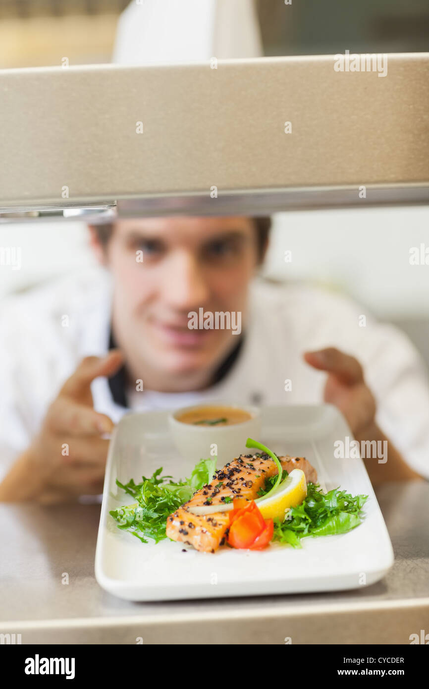 Chef handing salmon dinner through order station Stock Photo - Alamy