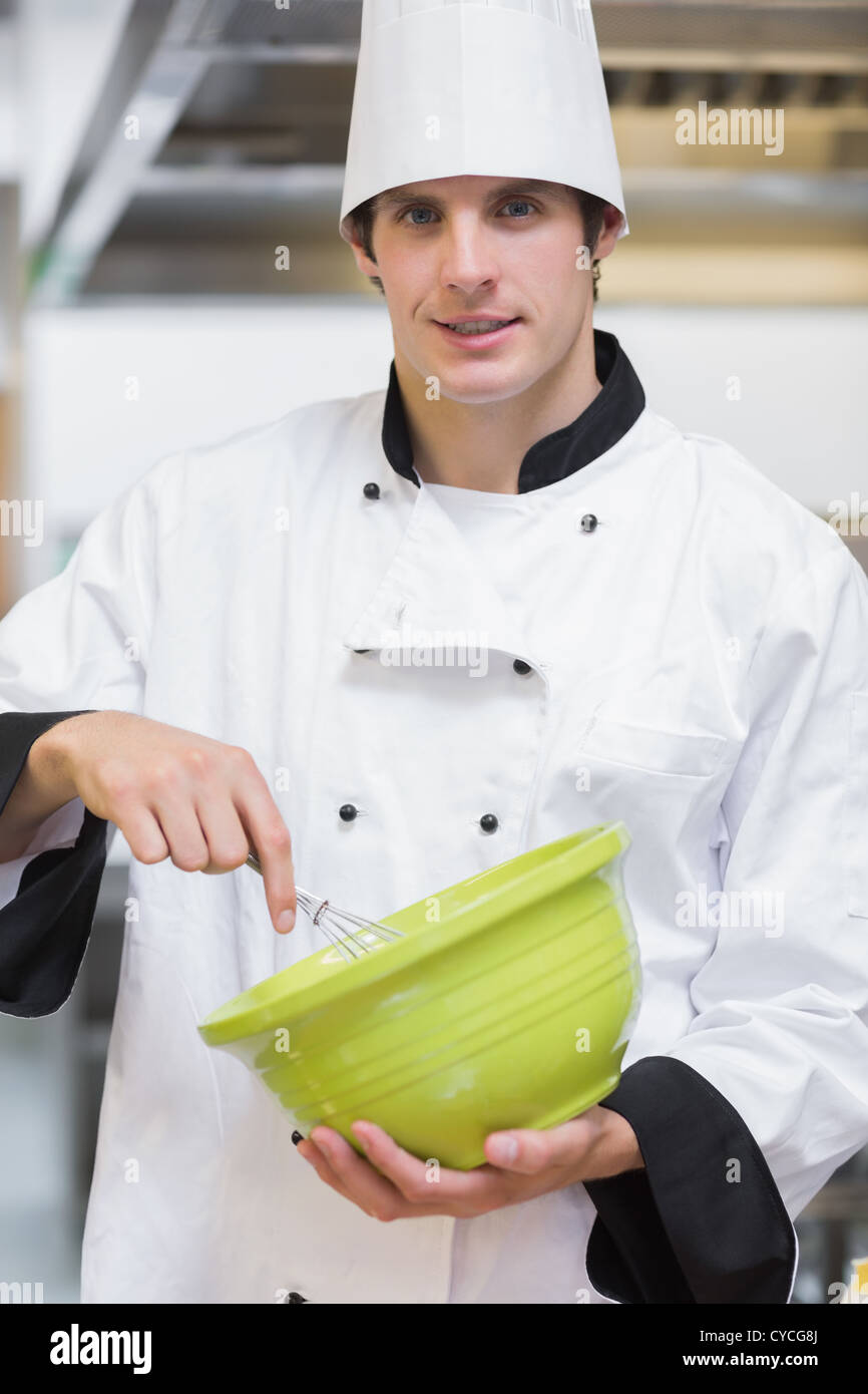 Smiling chef mixing with whisk Stock Photo - Alamy