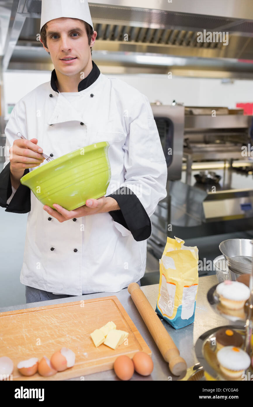 Smiling pastry chef mixing dough Stock Photo - Alamy