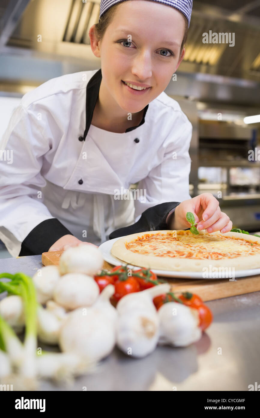 Smiling chef decorating the pizza Stock Photo - Alamy
