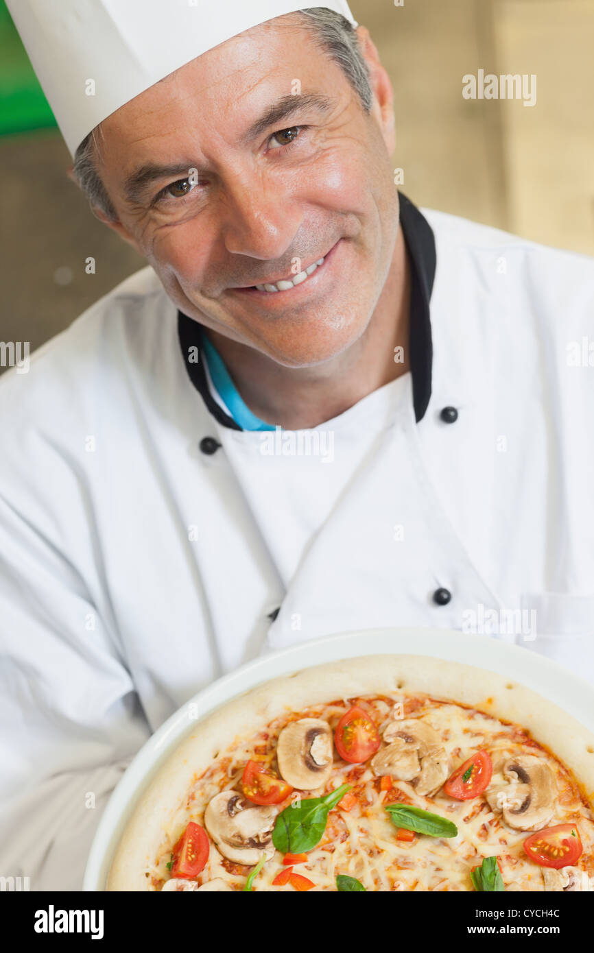 Smiling chef holding a pizza Stock Photo - Alamy
