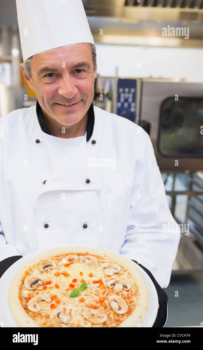 Smiling chef showing pizza Stock Photo - Alamy