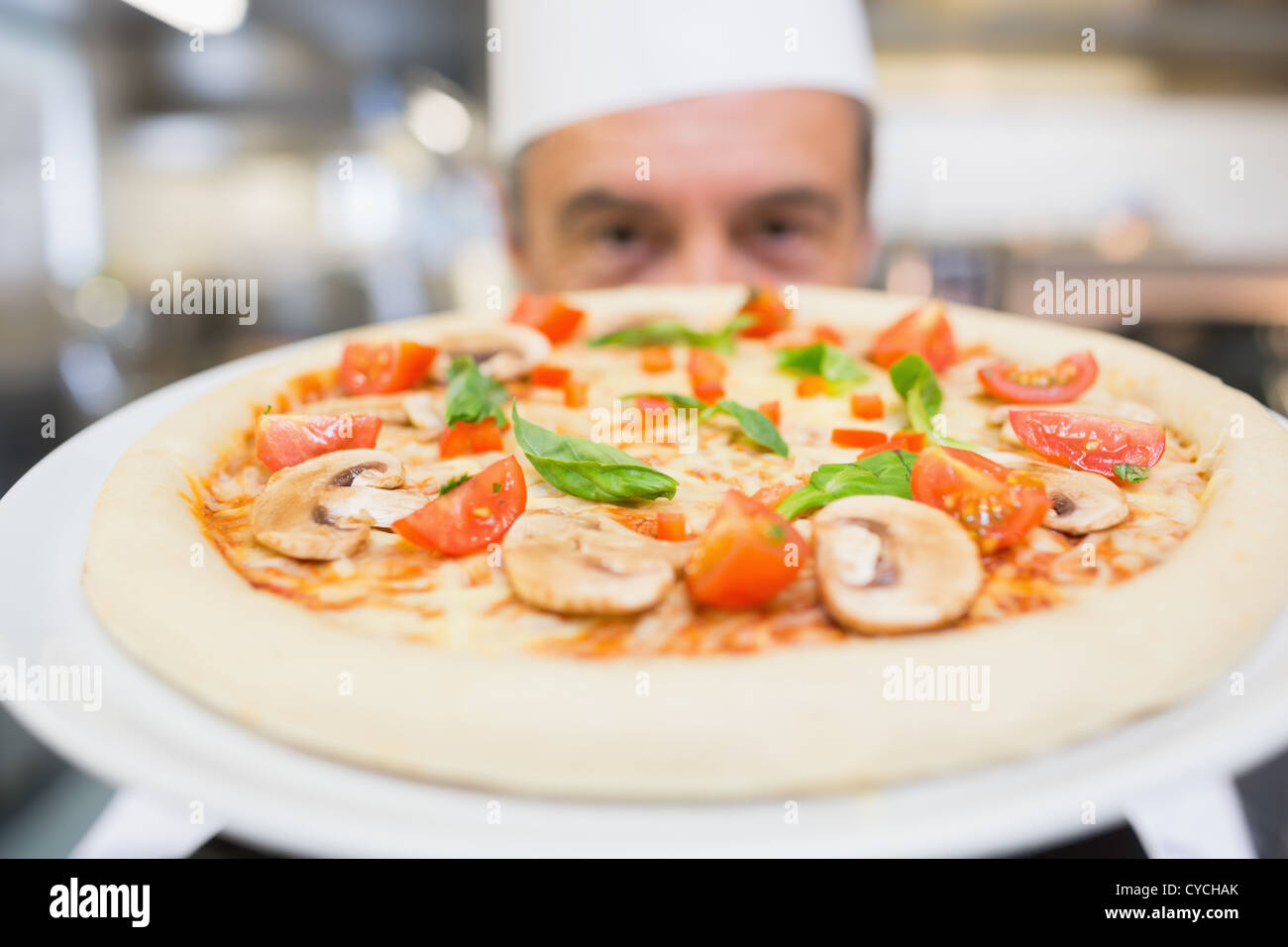 Cook presenting a pizza Stock Photo - Alamy