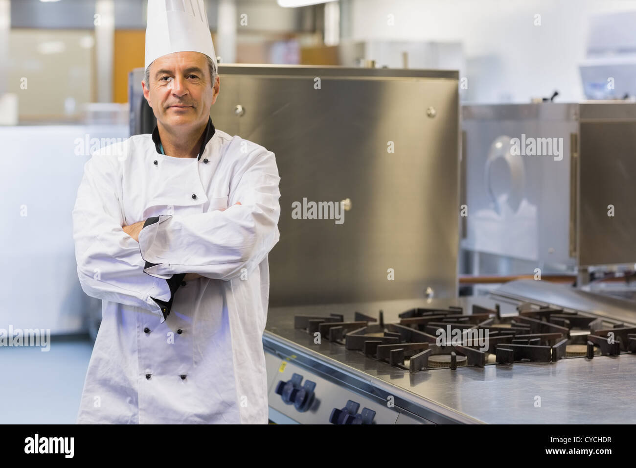 Cook with arms crossed standing in the kitchen Stock Photo - Alamy
