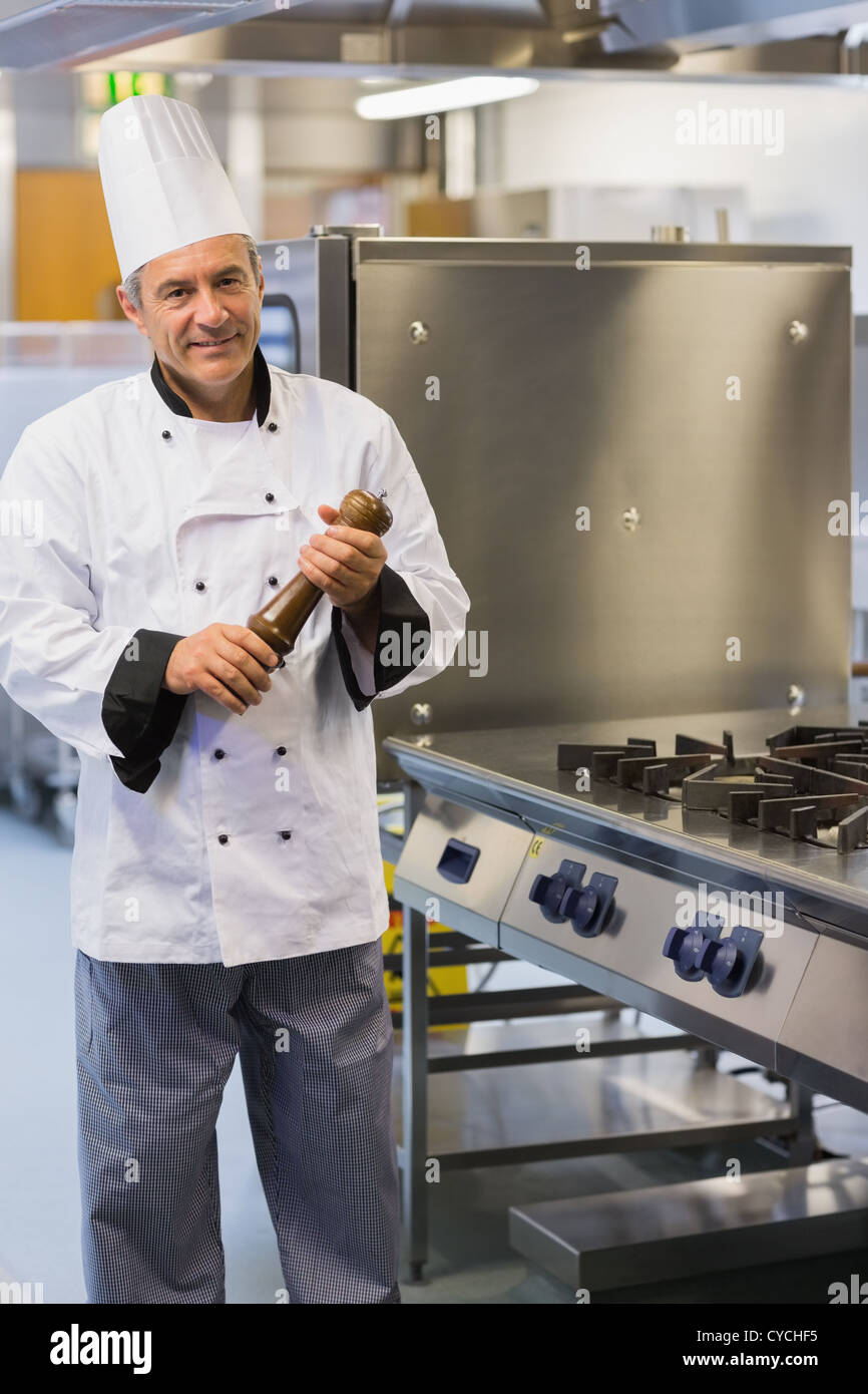 Smiling chef holding a pepper mill Stock Photo - Alamy