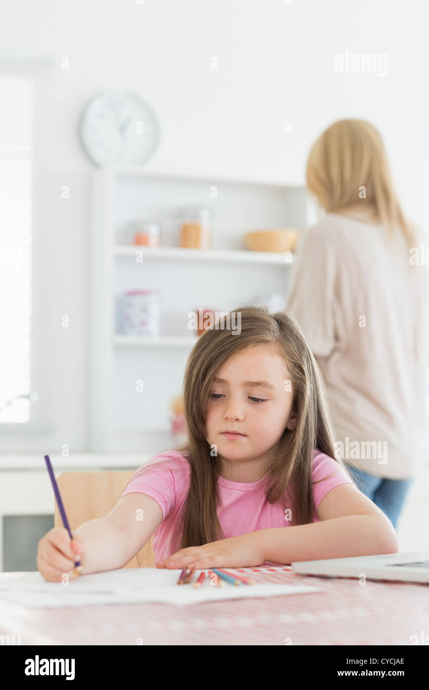 Girl sitting at the table drawing in kitchen Stock Photo - Alamy