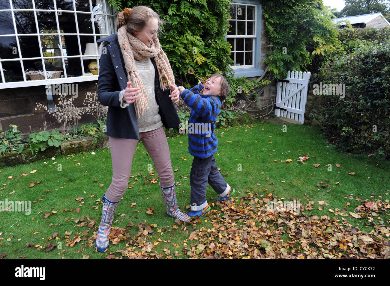 Children having a leaf fight in the garden in north yorkshire Stock ...