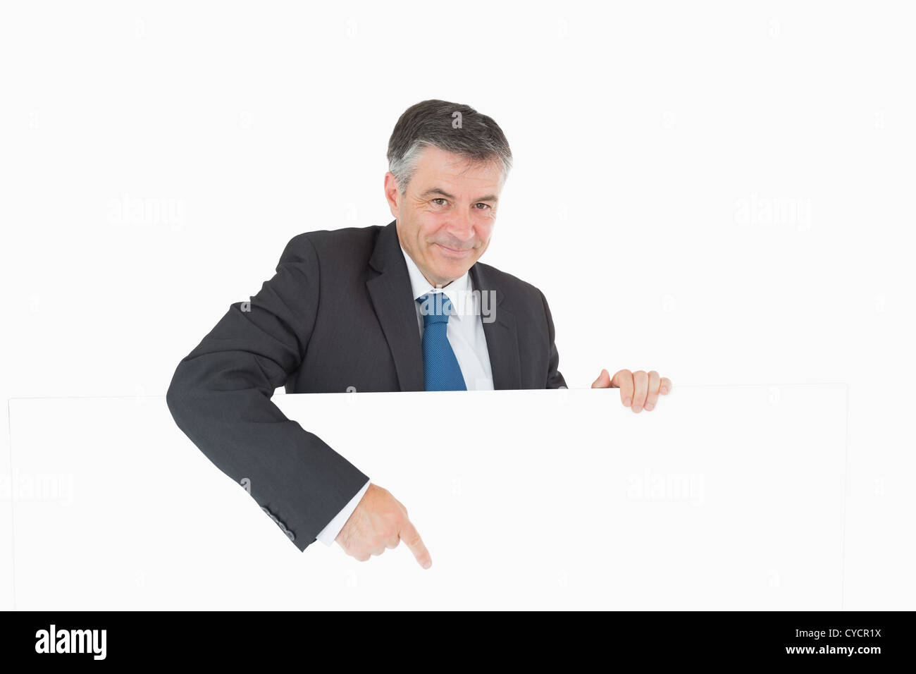 Smiling businessman pointing to board Stock Photo - Alamy