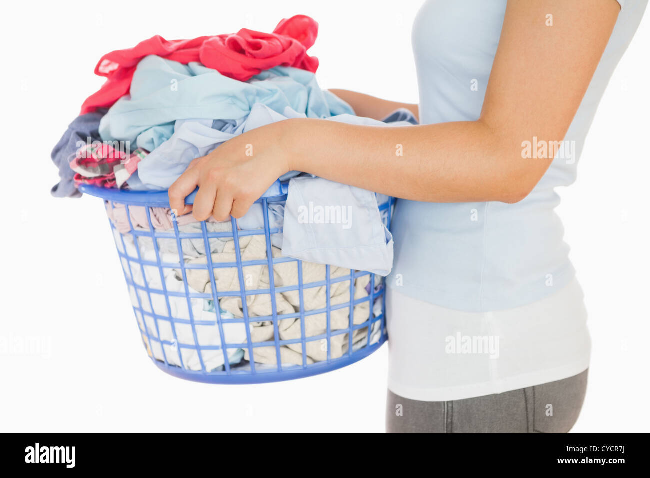 Woman holding a basket overflowing of laundry Stock Photo - Alamy