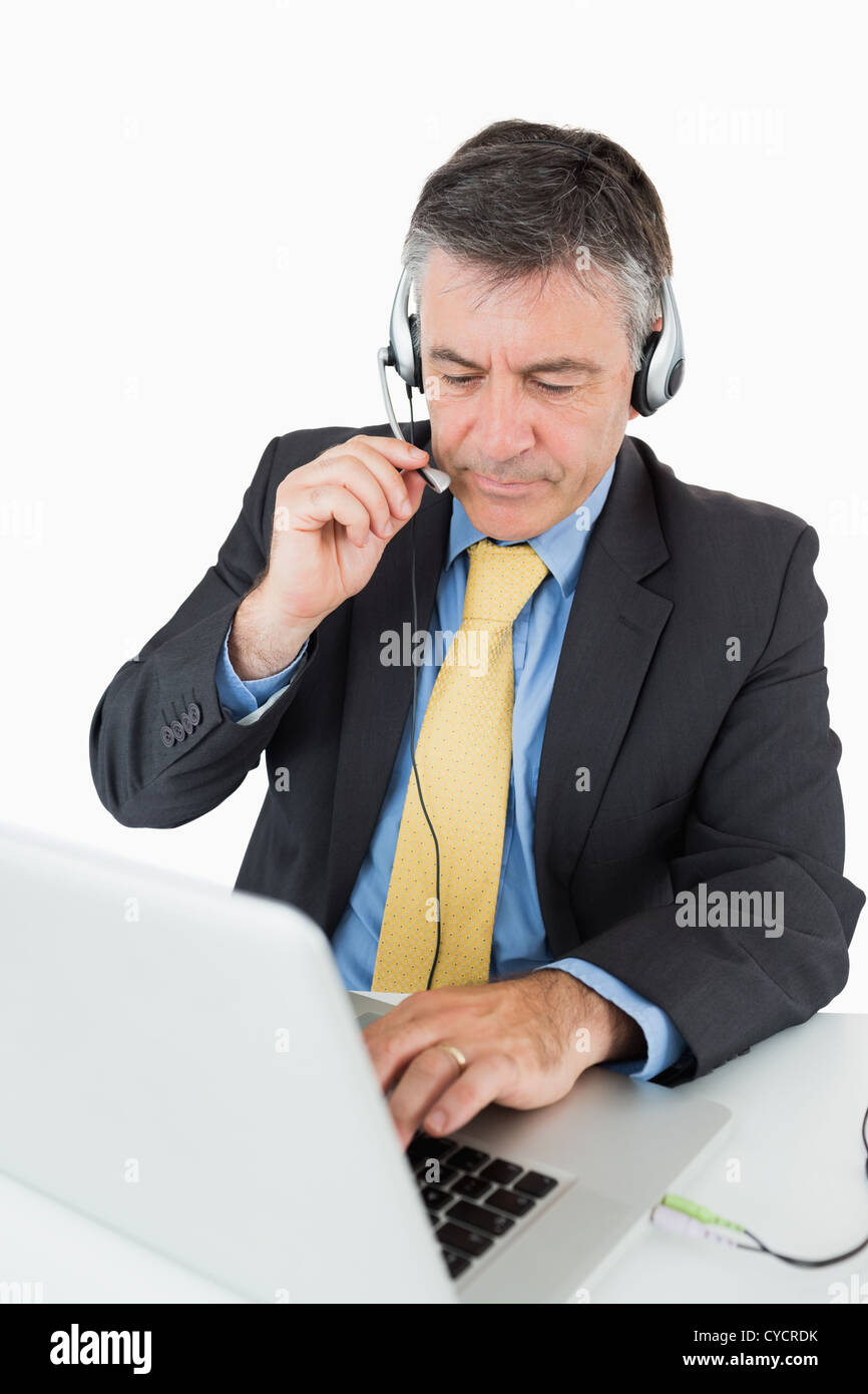 Man sitting at his desk with headphones Stock Photo - Alamy
