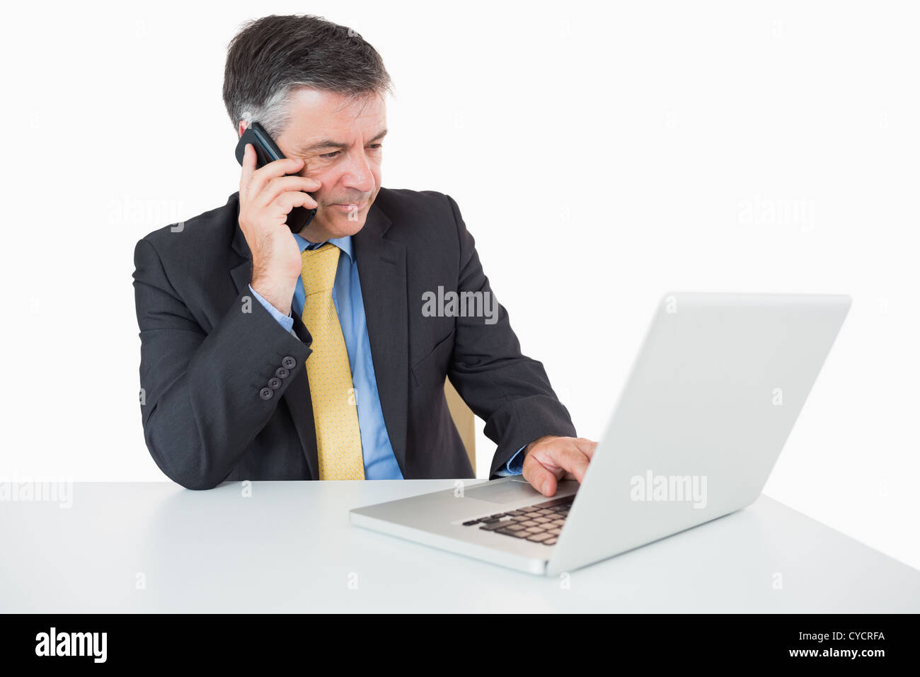Man phoning while writing on laptop Stock Photo - Alamy