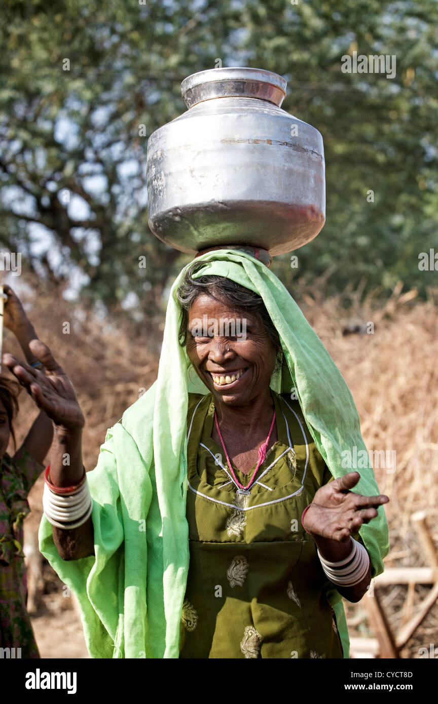 Indian woman smiling with a metal pot on her head Stock Photo - Alamy