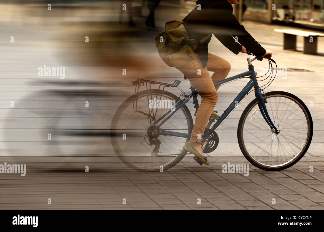 Unidentified person riding a bicycle at speed along a pavement Stock ...