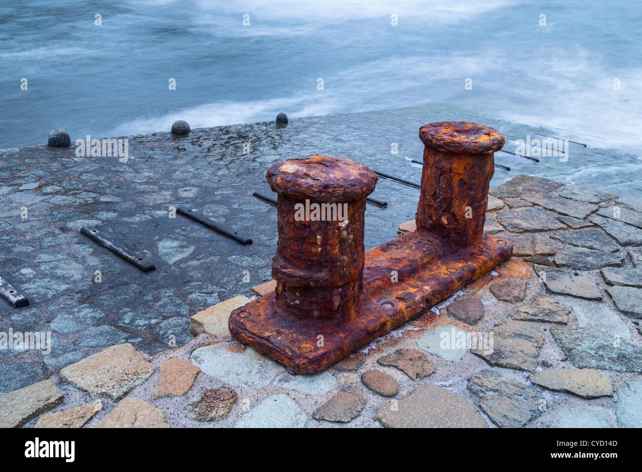 Rusty bollards on coastal slipway Stock Photo - Alamy