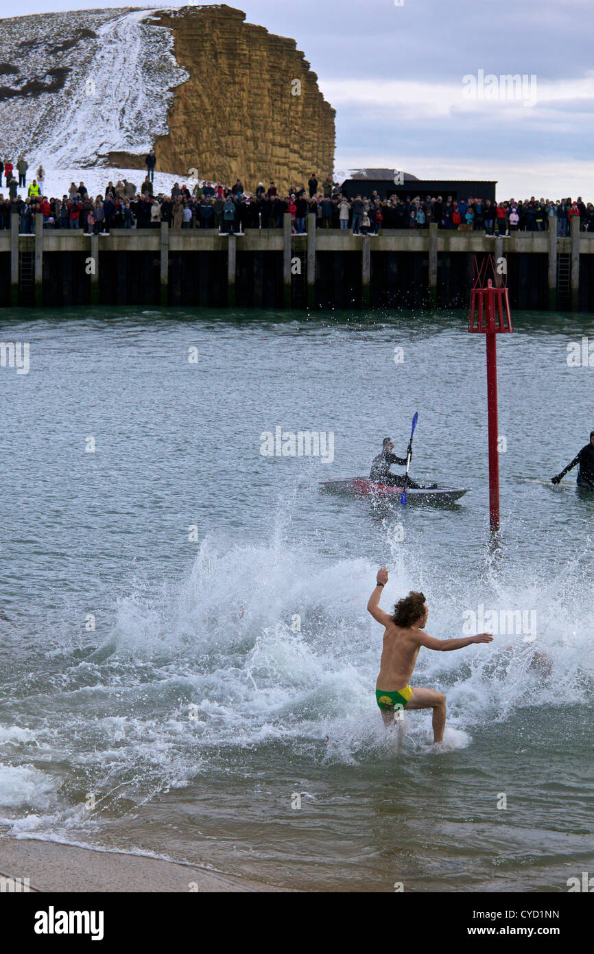 A swimmer runs into the sea during the Boxing Day West Bay wallow. West ...