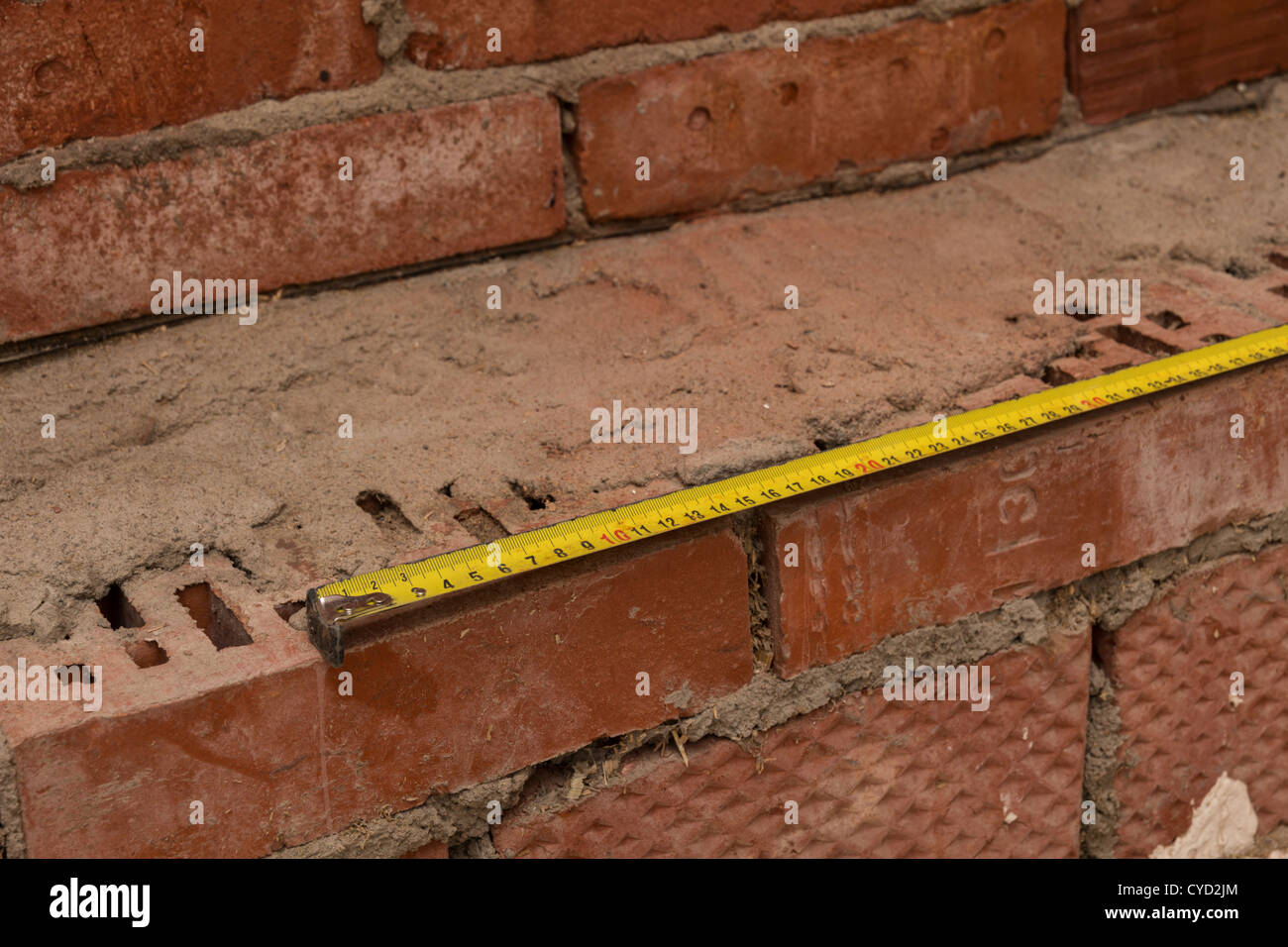 measuring brick wall with a yellow ruler Stock Photo - Alamy