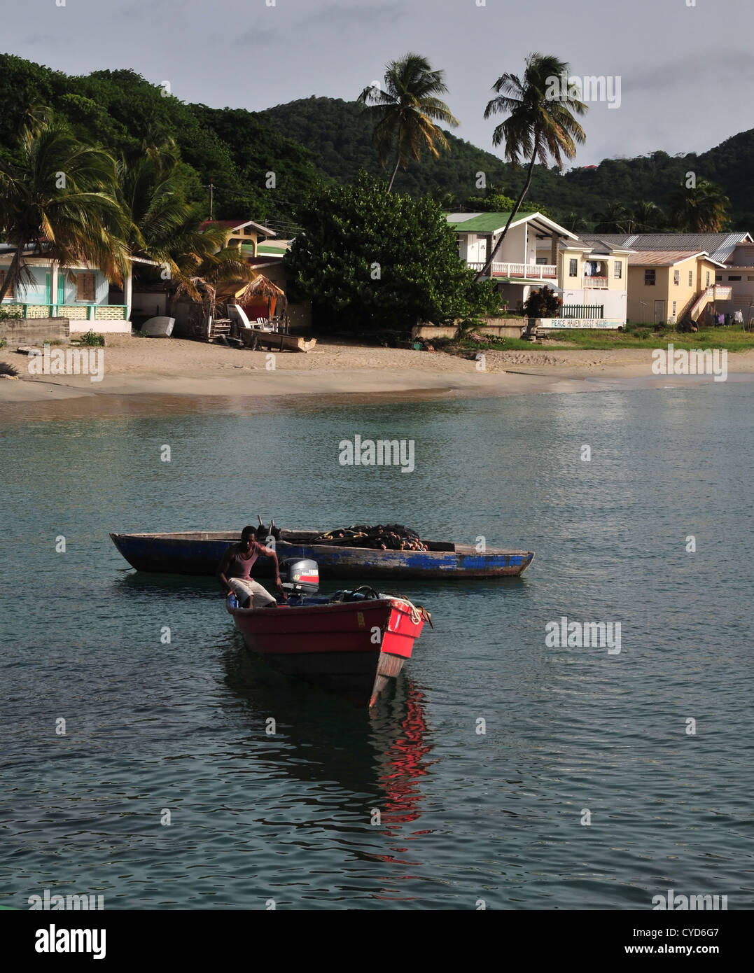 Sunset portrait, to beach buildings, boat with net, man steering red ...