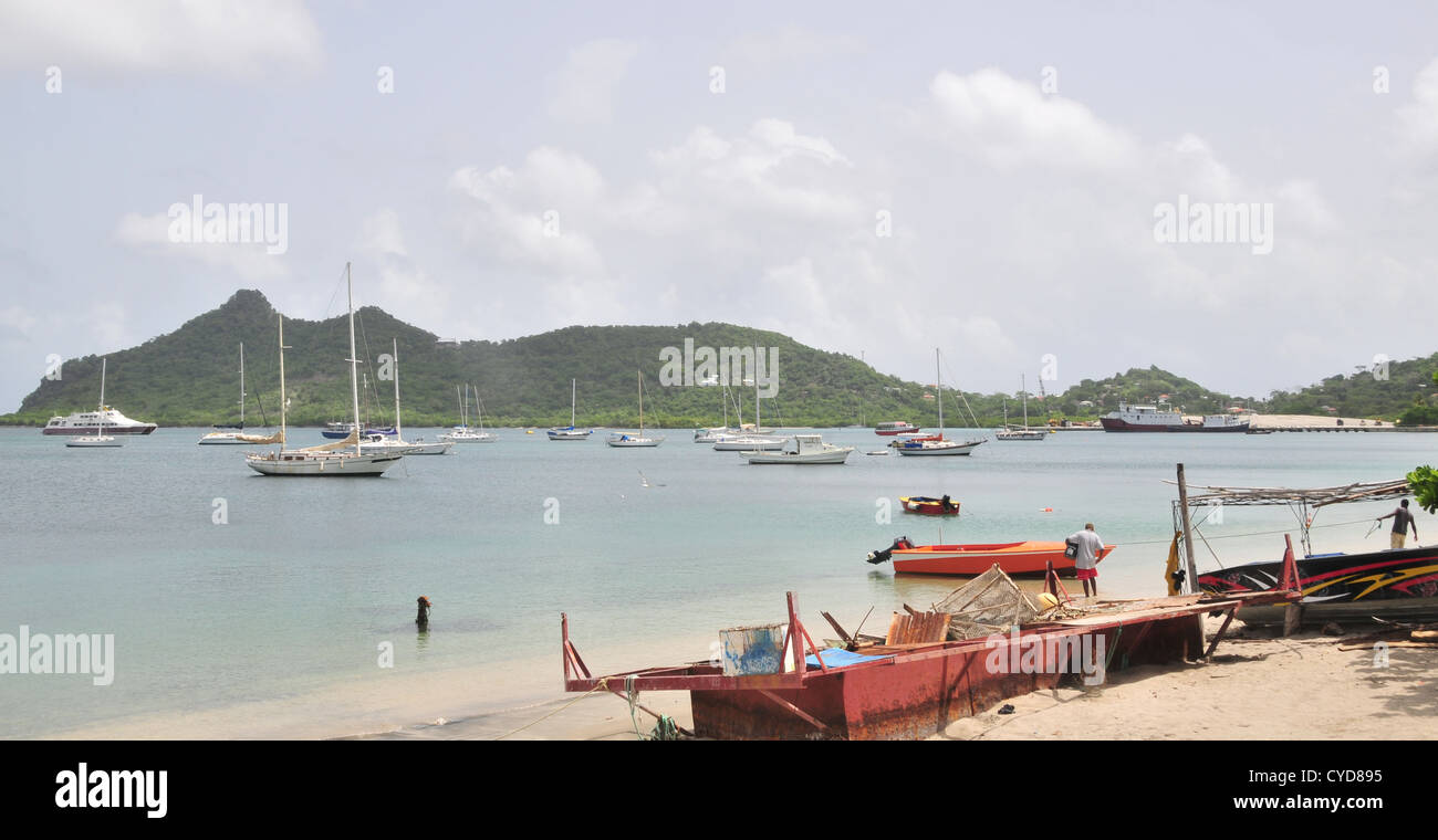 Sunny beach view, towards moored yachts and green trees hills, man ...