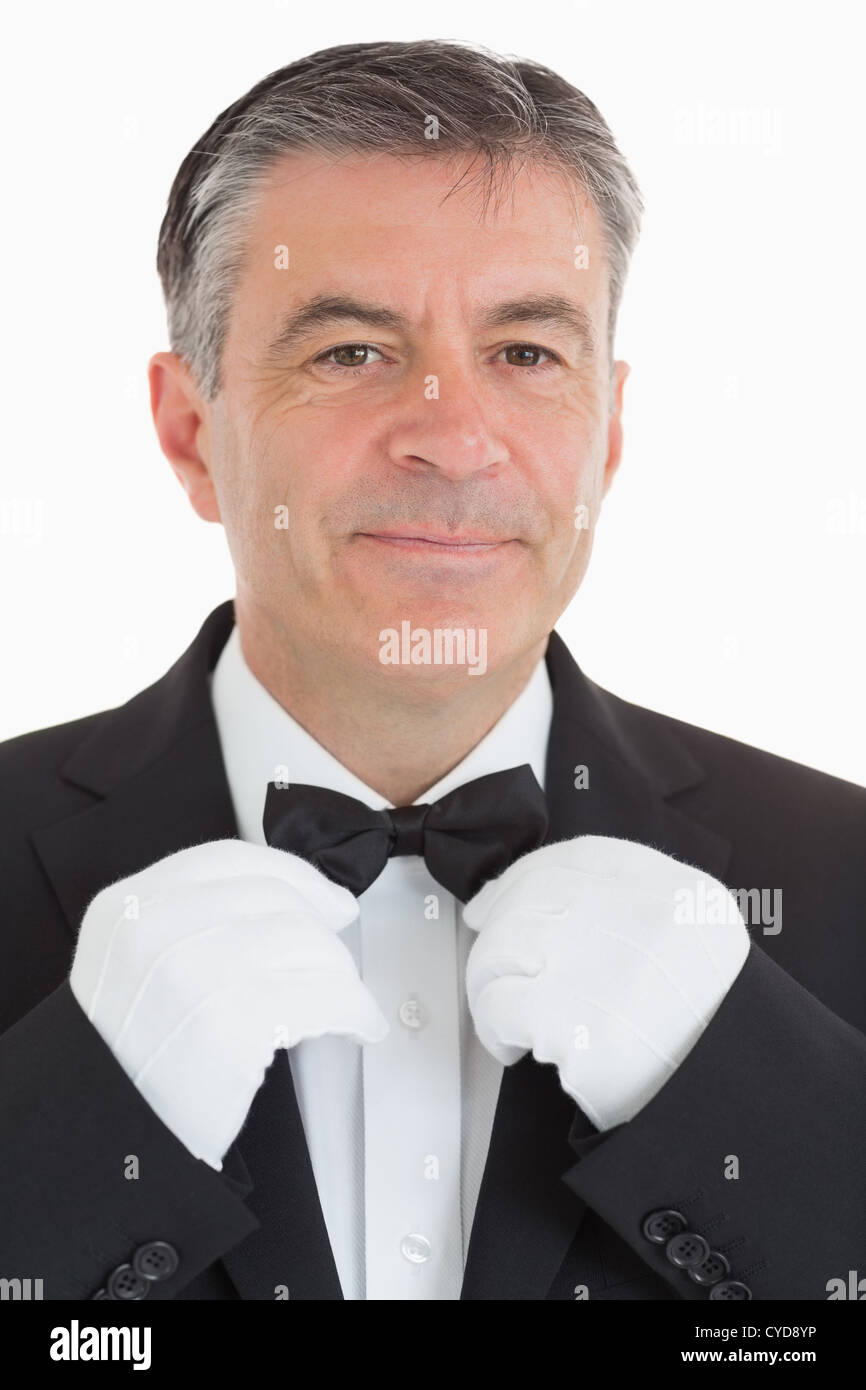 Cheerful waiter adjusting his bow tie Stock Photo - Alamy