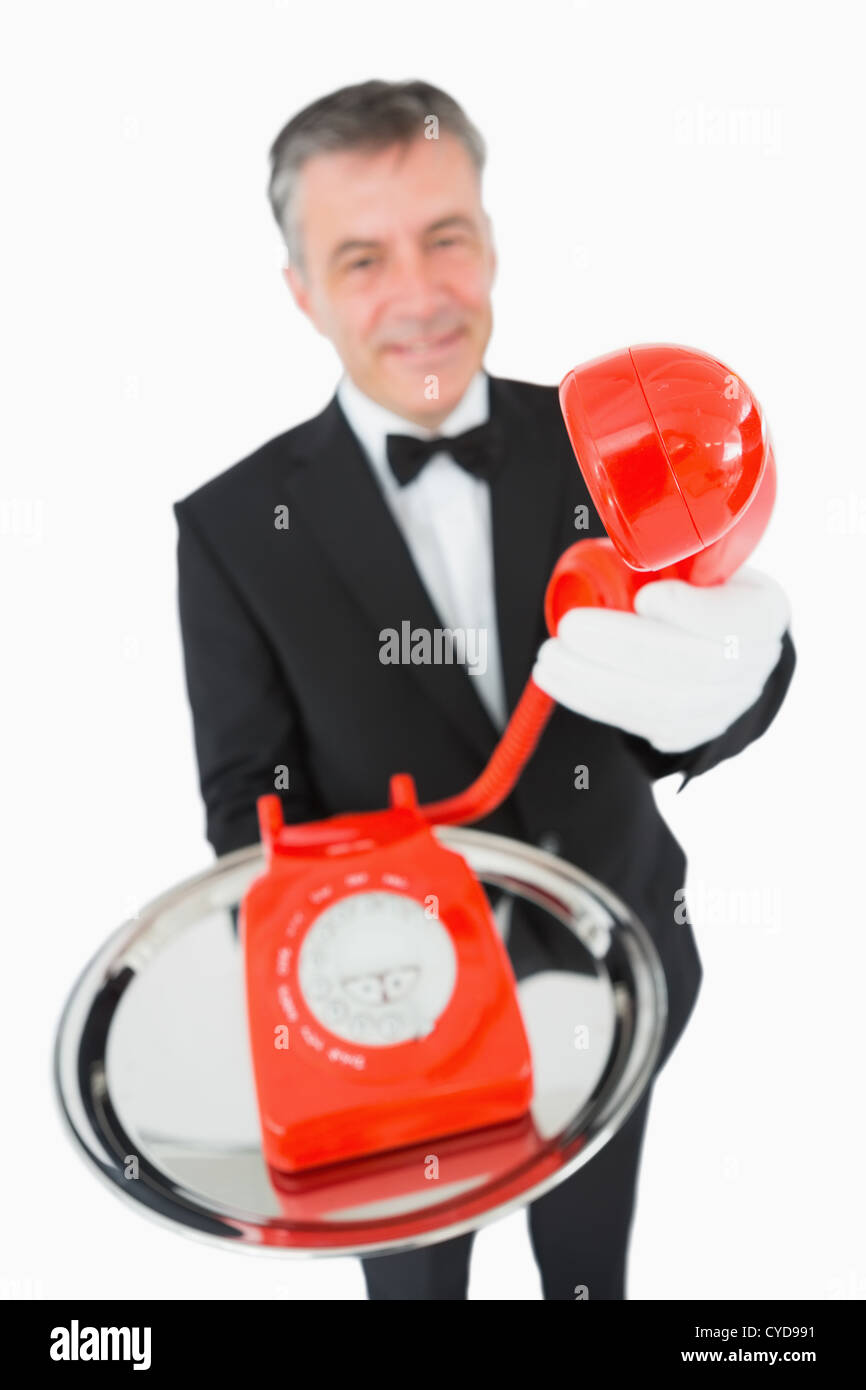 Waiter giving the phone to someone Stock Photo - Alamy