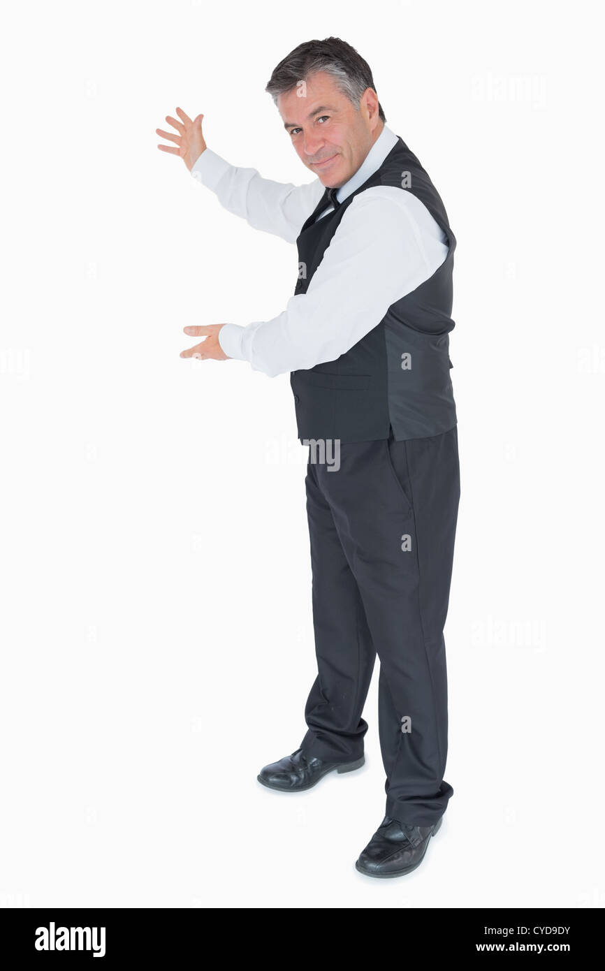 Smiling man presenting something Stock Photo - Alamy