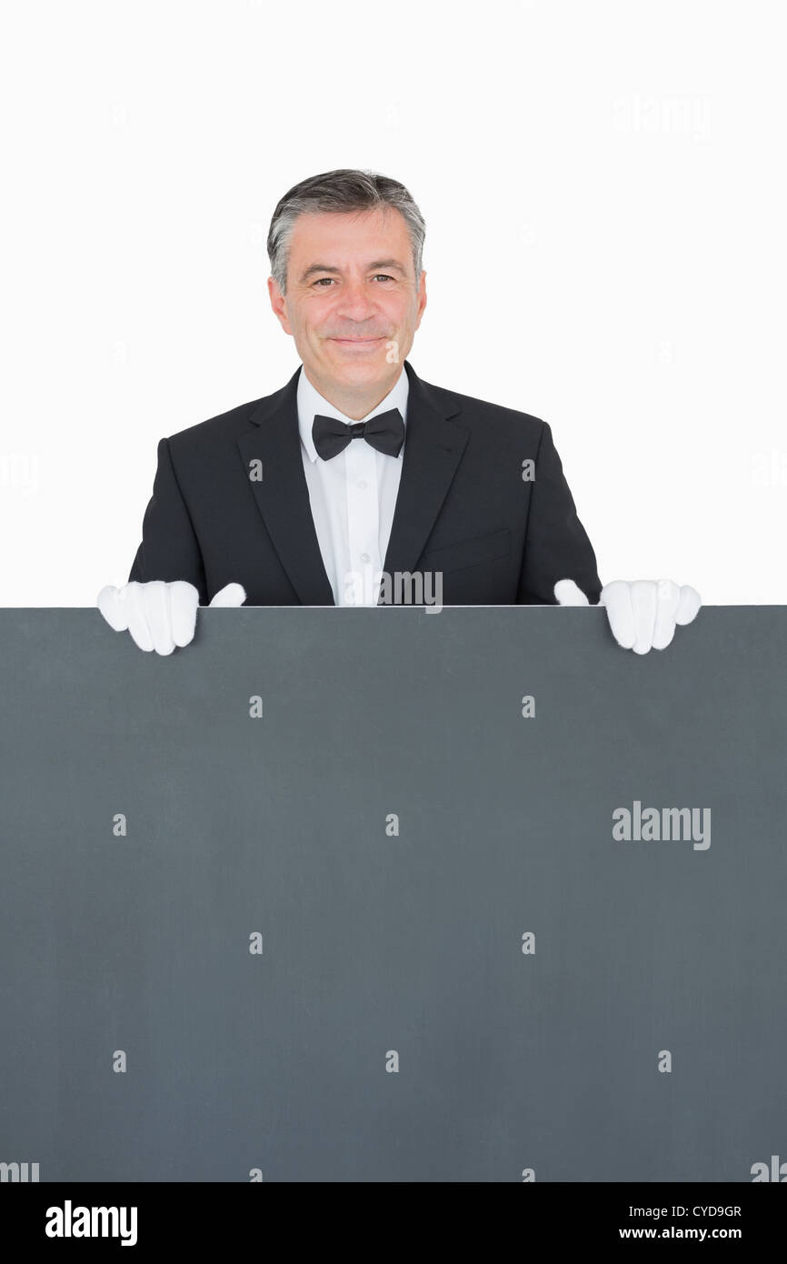 Waiter standing behind grey sign Stock Photo - Alamy