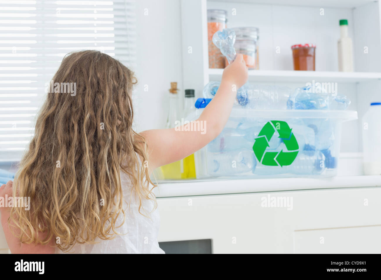Girl putting bottle in recycling box Stock Photo - Alamy