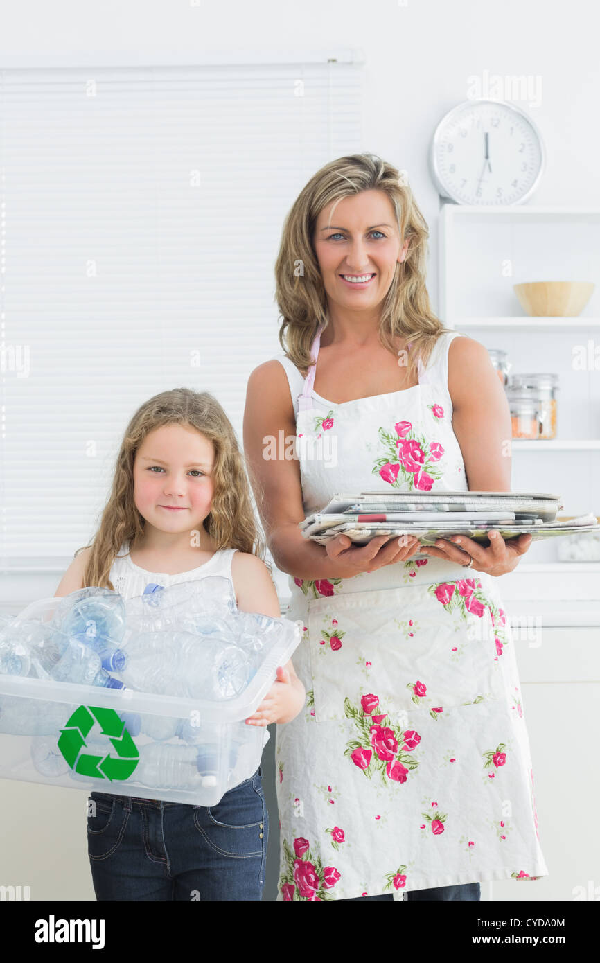 Mother and daughter standing in the kitchen with waste for recycling ...