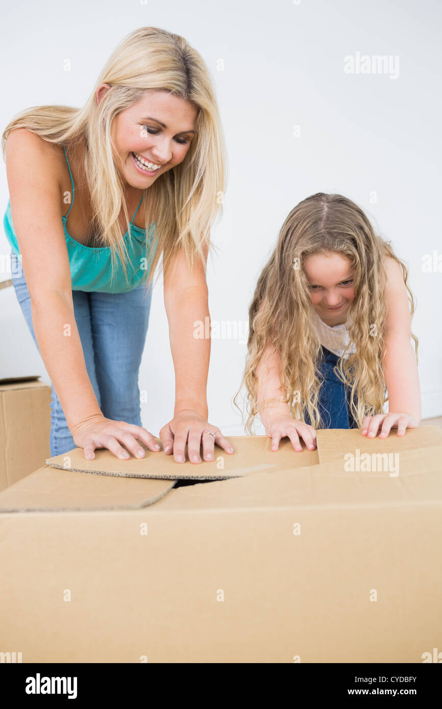 Mother and daughter closing moving boxes Stock Photo - Alamy