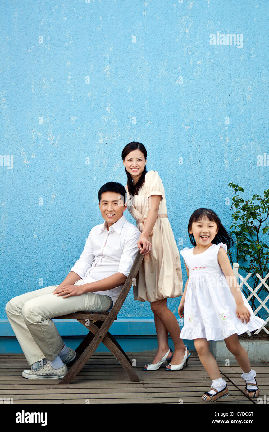 Chinese family of Three , standing before blue wall Stock Photo - Alamy