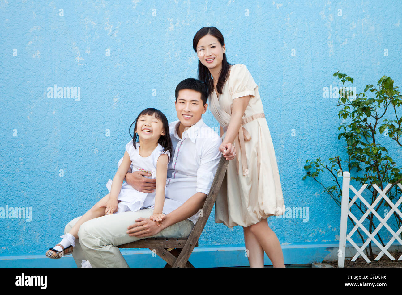 Chinese family of Three , standing before blue wall Stock Photo - Alamy