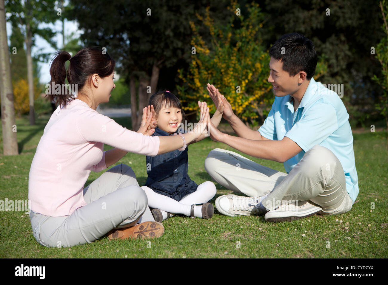 Chinese family of three, playing game, on the lawn Stock Photo - Alamy
