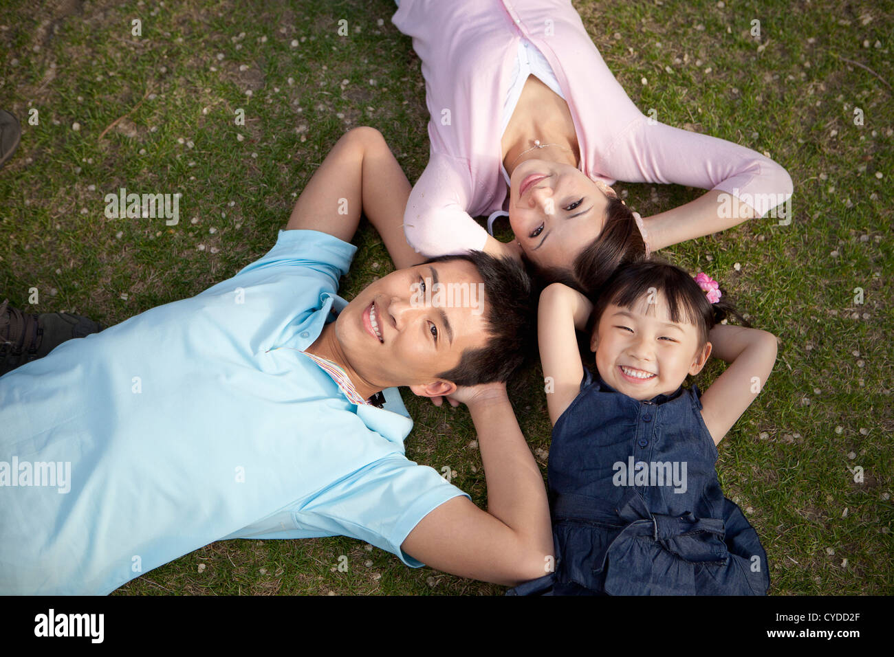 Chinese family of three, lying on the lawn Stock Photo - Alamy