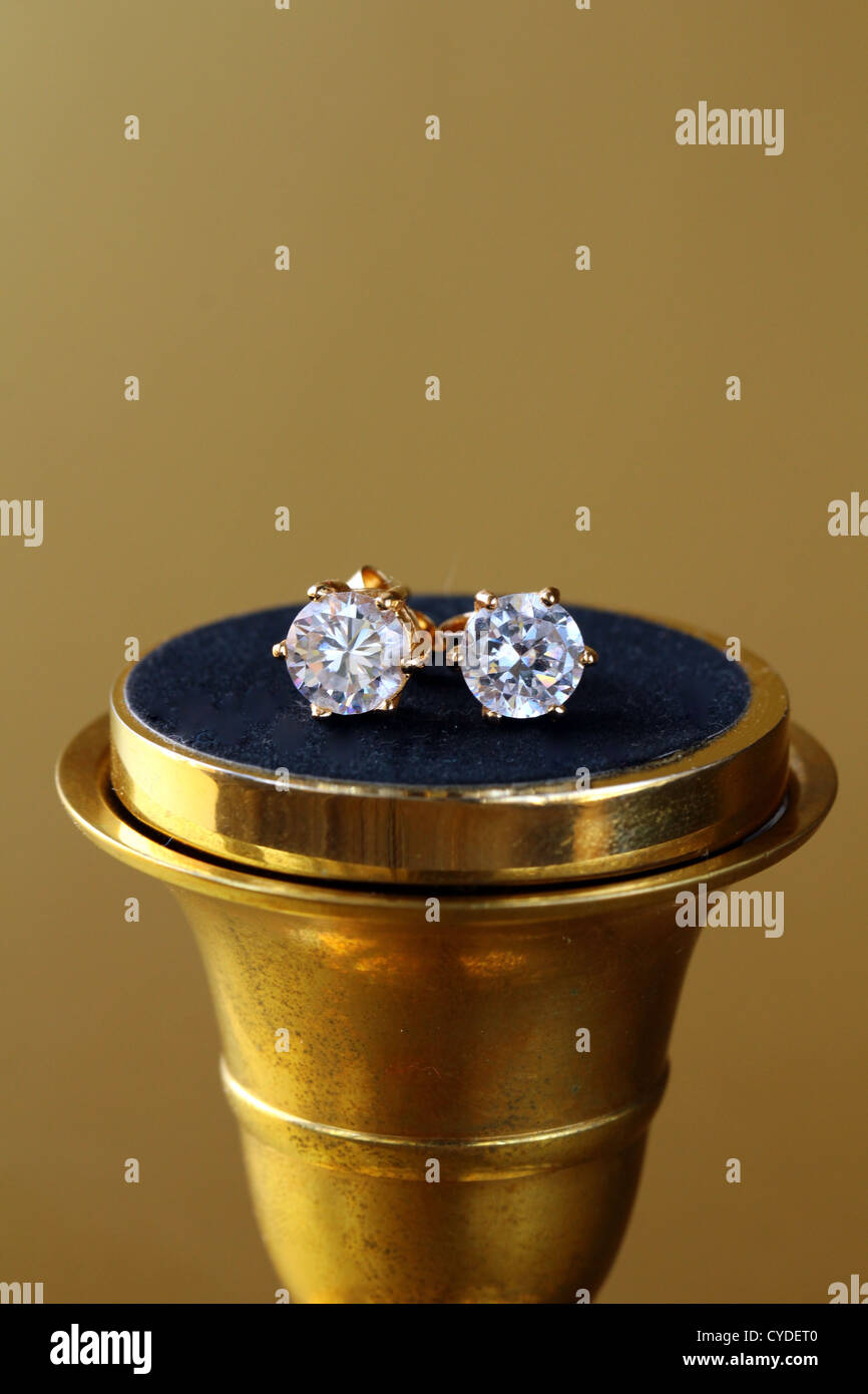 gold earrings stud with diamonds on gold background Stock Photo - Alamy
