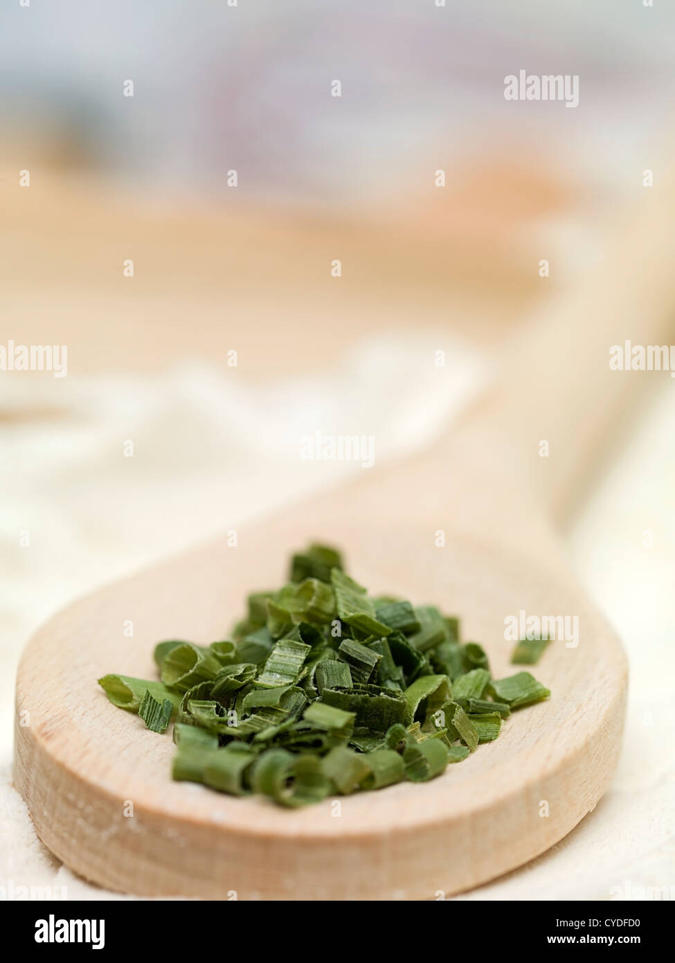 closeup detail of some fresh, green condiment, placed on a wooden spoon ...