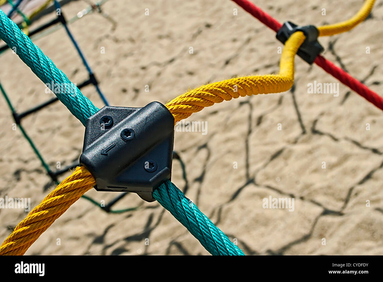 Colored ropes fastened together, on a sand playground for children ...