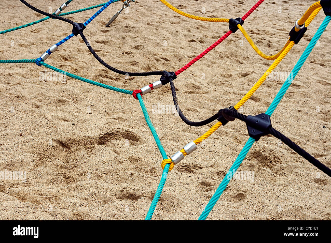 Colored ropes fastened together, on a sand playground for children ...