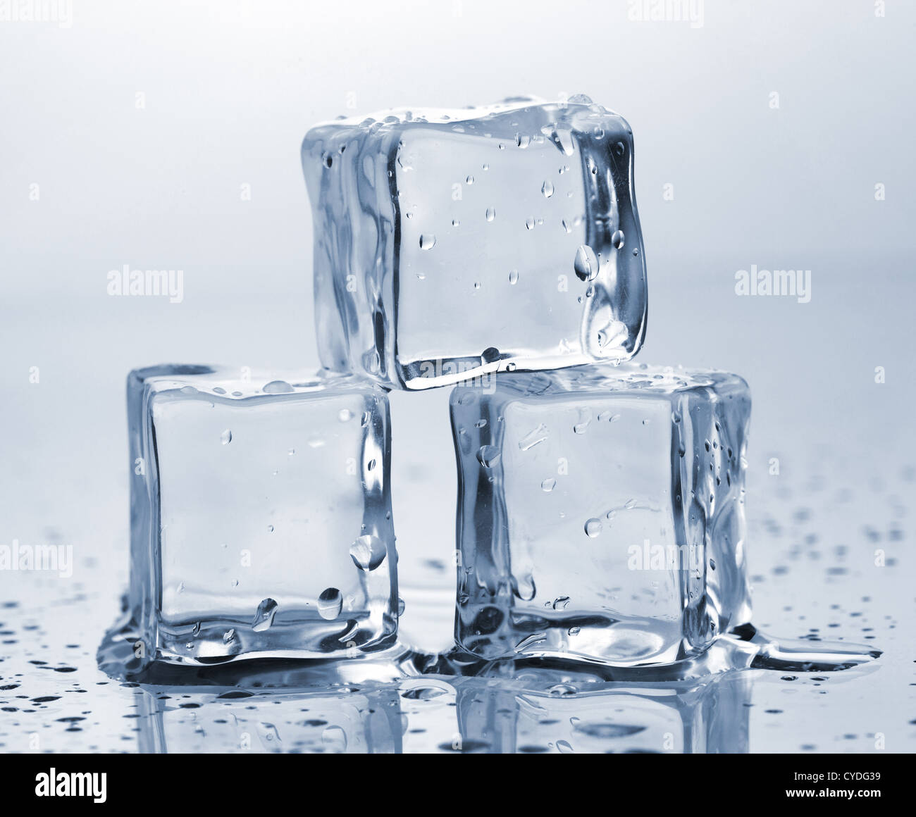 Three ice cubes on glass table Stock Photo - Alamy