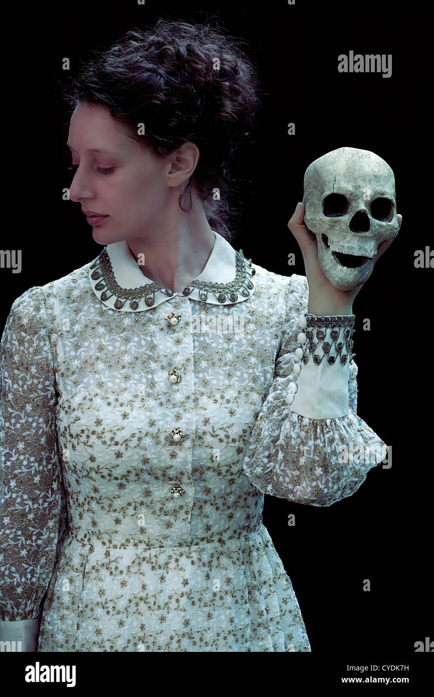 a woman in a victorian dress is holding a skull Stock Photo - Alamy