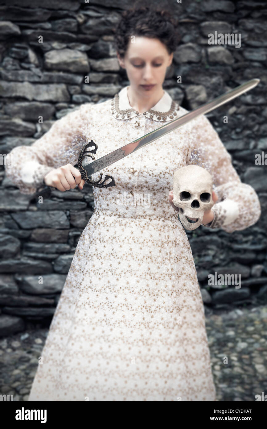 a woman in a victorian dress with sword and skull Stock Photo - Alamy