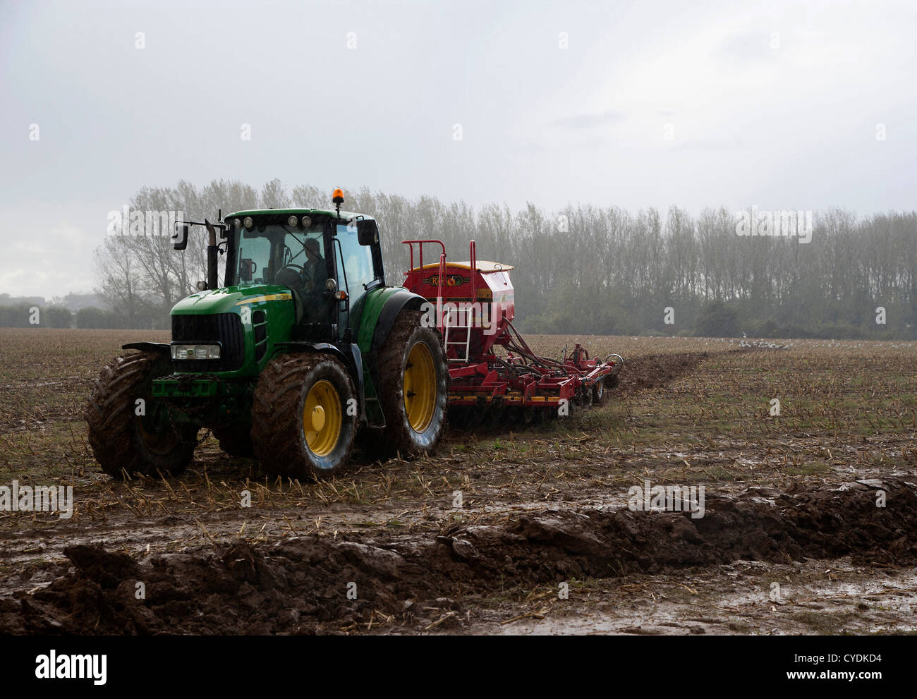 Tractor on a field in the rain Stock Photo - Alamy