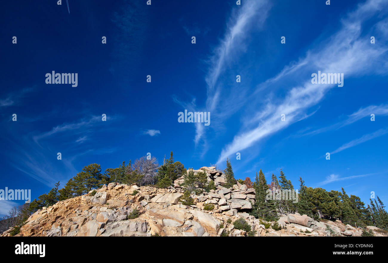 A brilliant blue sky with streaky clouds and a jet entering the top ...
