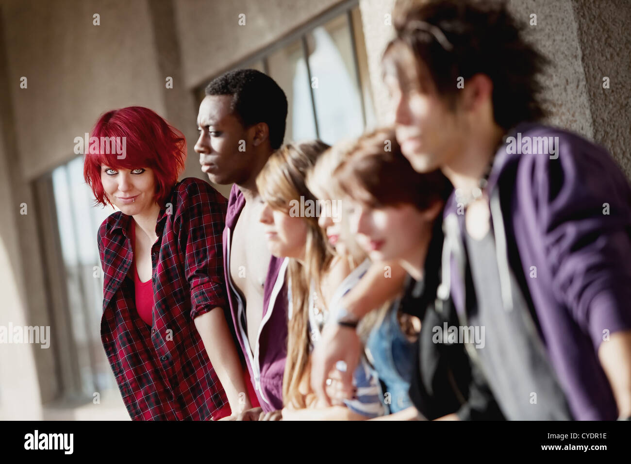 A group of young punk rock teens stare off into the distance as one ...