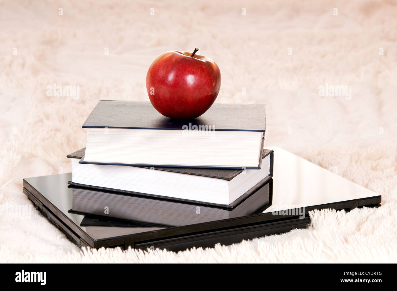 red apple lie on pile the books and laptop Stock Photo - Alamy