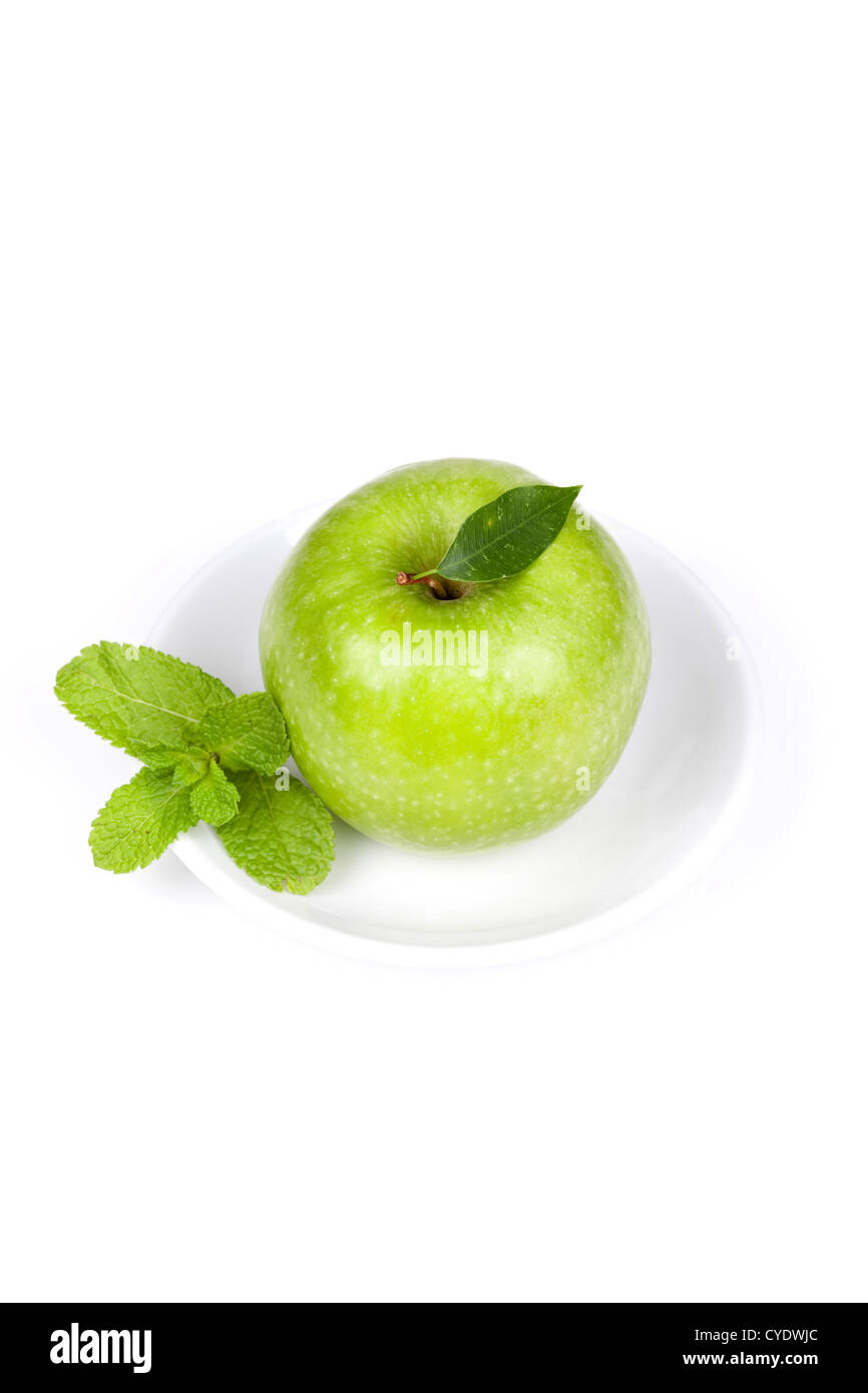 A Ripe Green Apple with mint on plate isolated on white background ...
