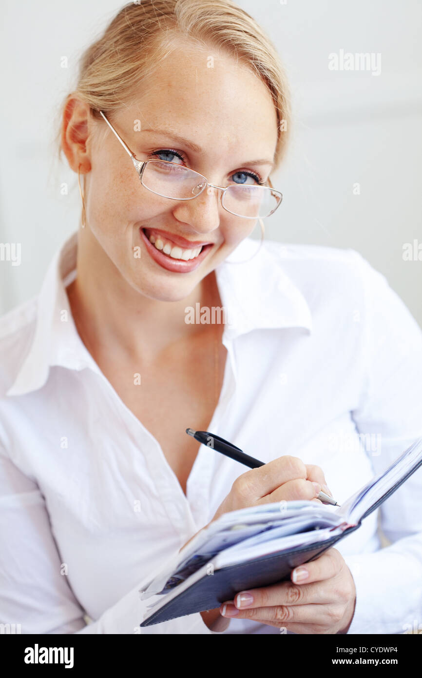 Portrait of a smiling business woman making notes Stock Photo - Alamy