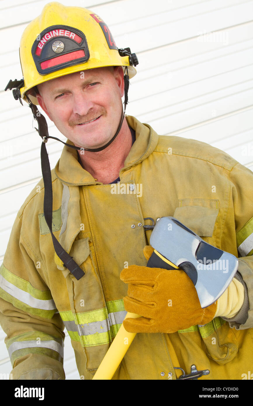 Smiling firefighter man holding axe Stock Photo - Alamy