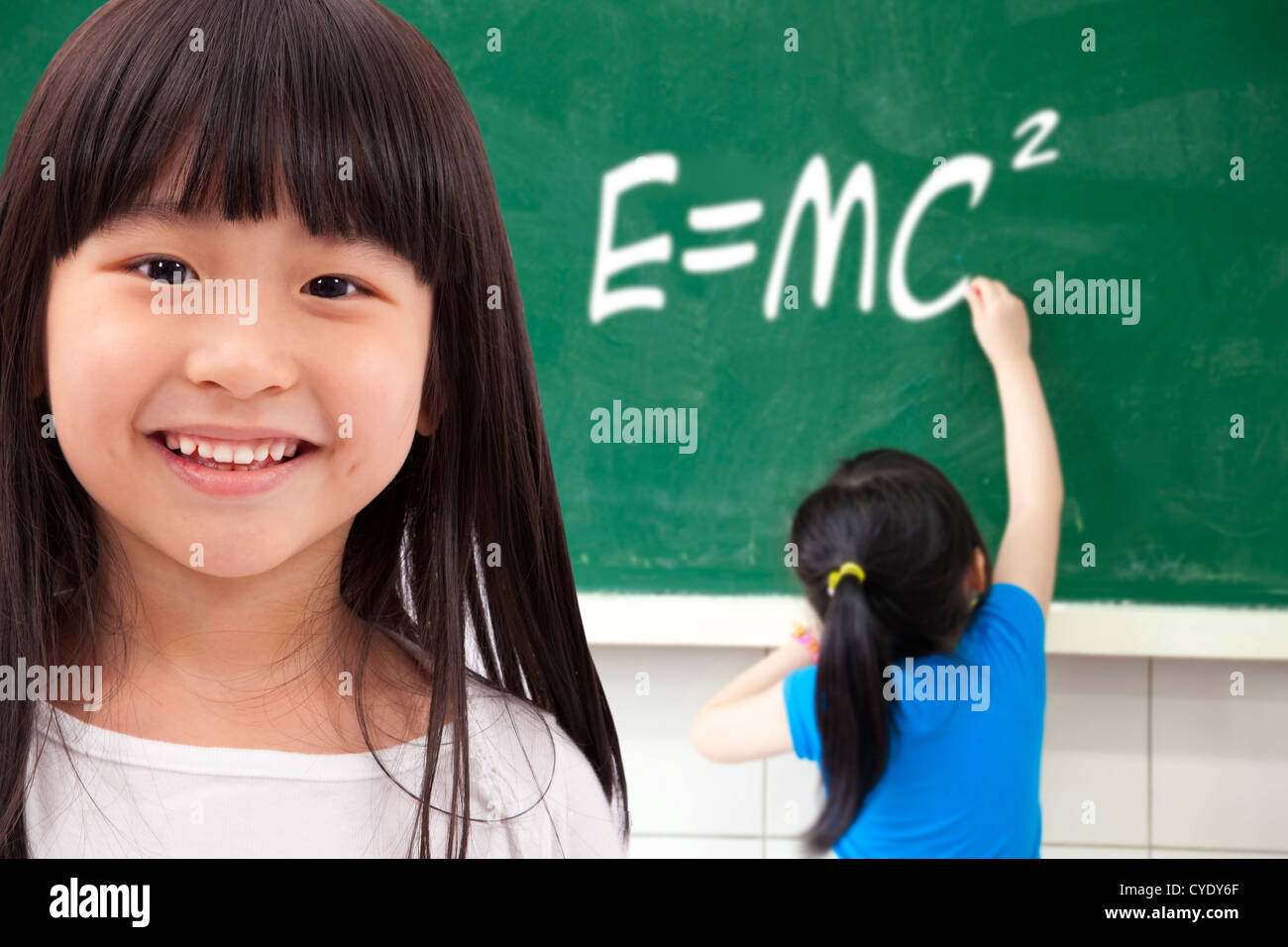 happy girls by chalkboard with e=mc2 Stock Photo - Alamy