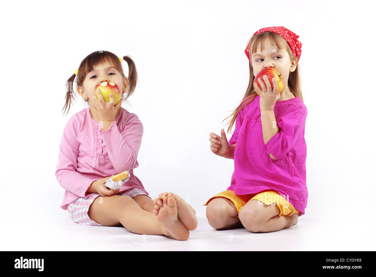 Portrait of cute kids eating apples over white Stock Photo - Alamy